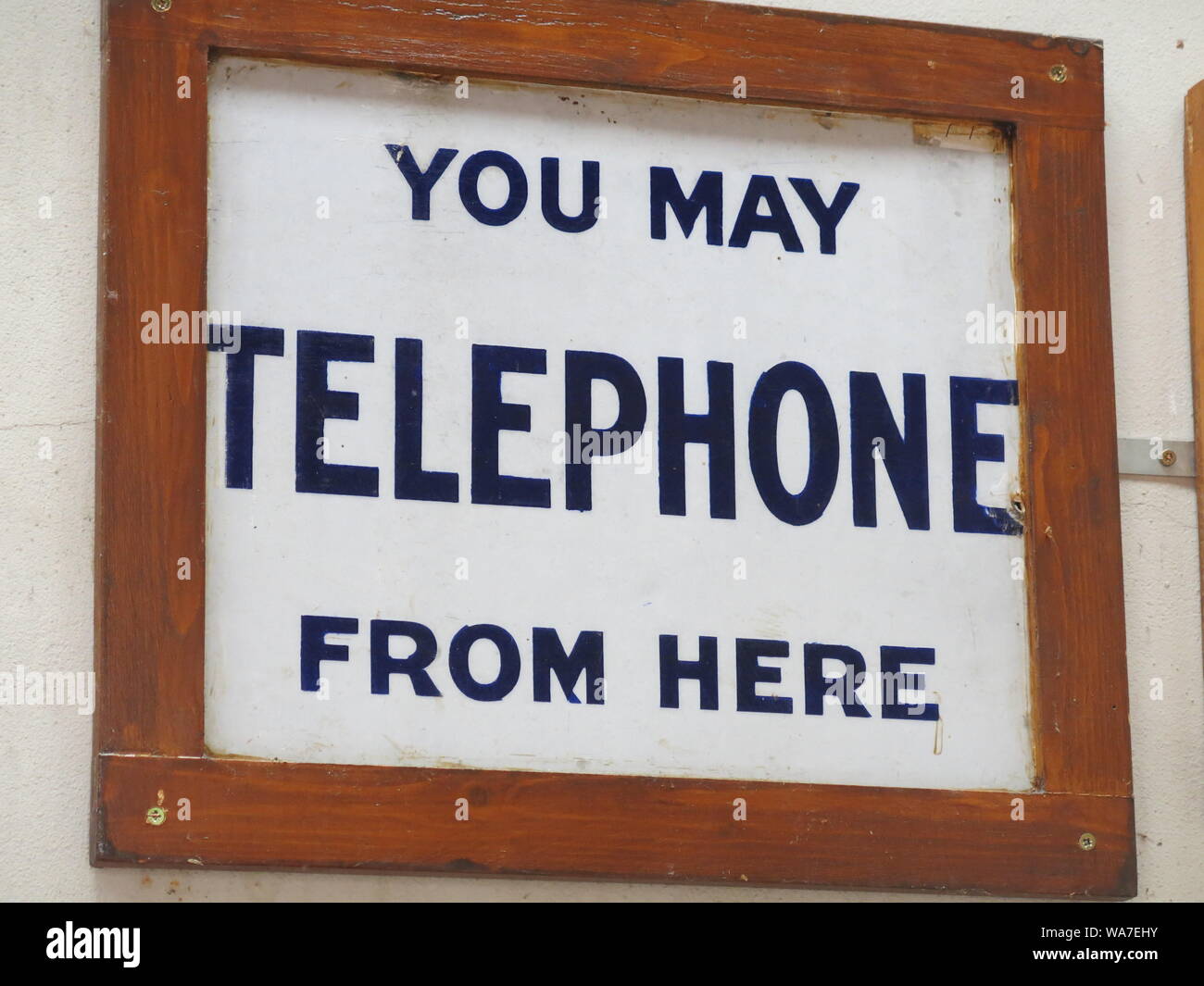 Close-up of the sign in an old-fashioned public telephone box, stating ...
