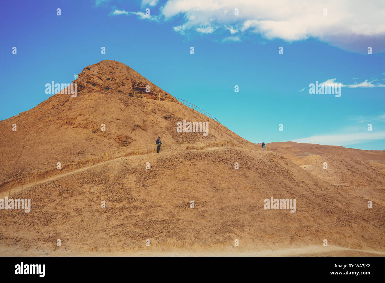 Desert landscape. A man stands on a hill. Climbing Masada from the west ...