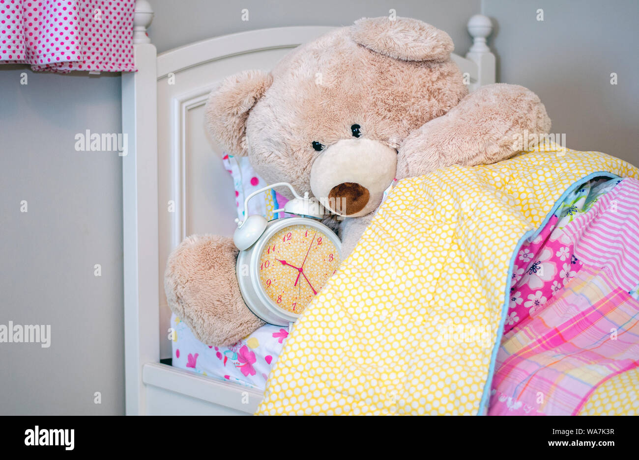 A giant bear checks his alarm clock. is it time to get up yet Stock ...