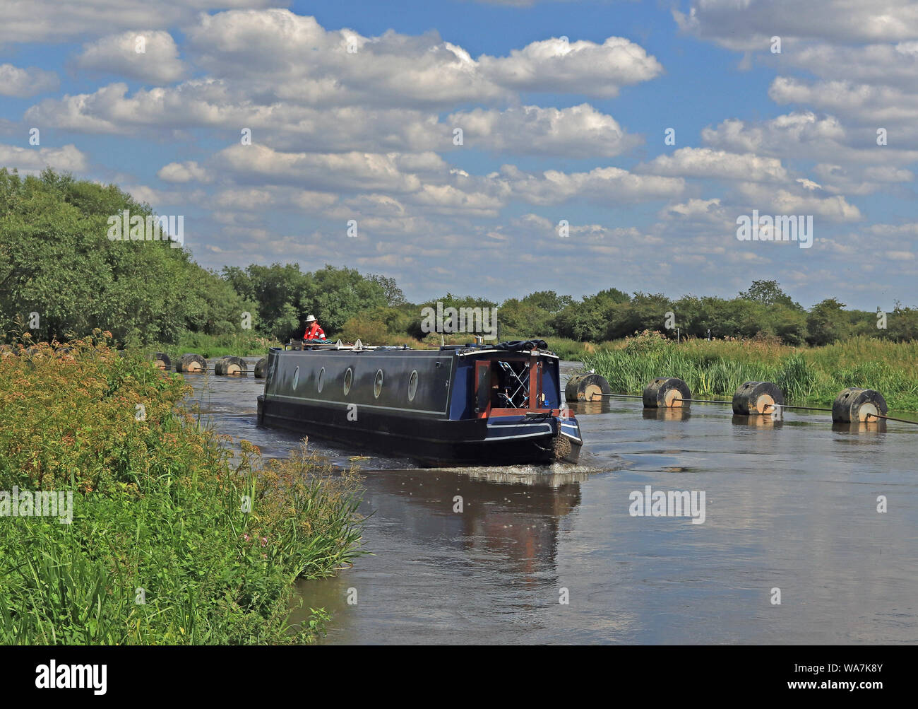 Canal boat navigating a river section of the trent hi-res stock ...