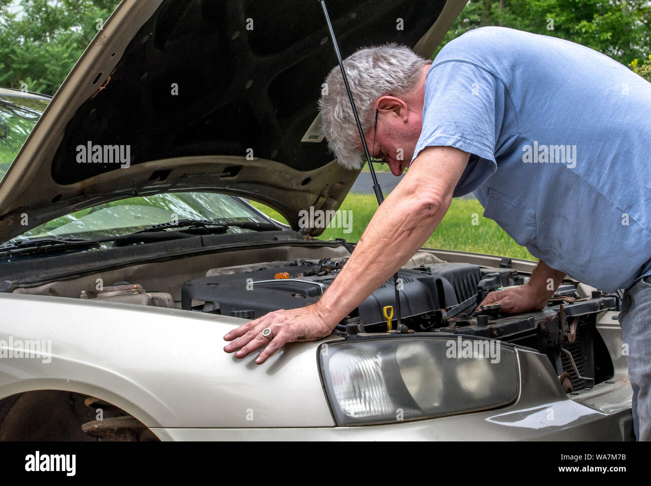 Mechanic examining under hood car hi-res stock photography and images ...