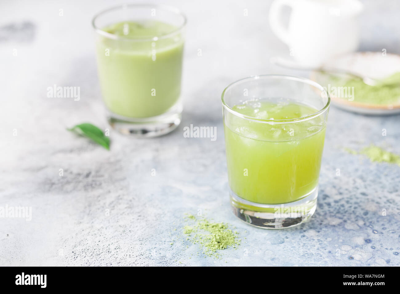 Iced Matcha green latte in glasses with matcha powder on light ...