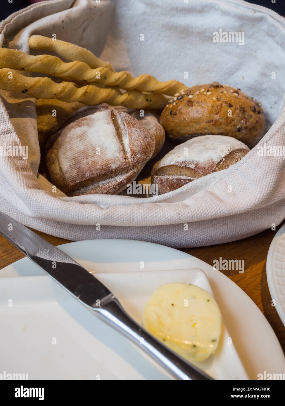 Bread and Italian grissini in basket with butter, restaurant starter ...