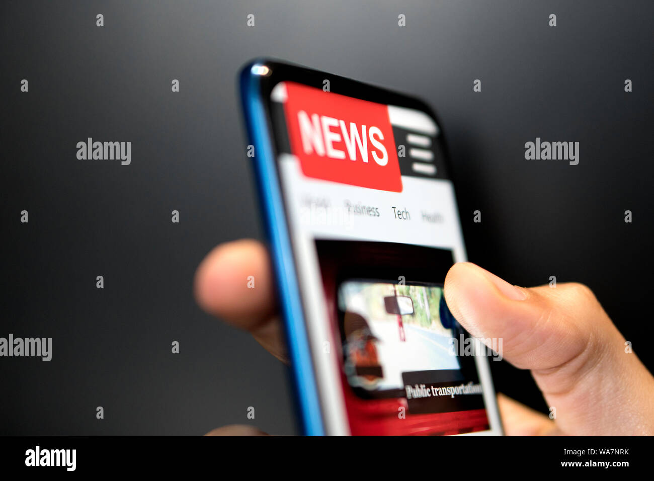 A man holding mobile smart phone with news on screen. Newspaper online ...