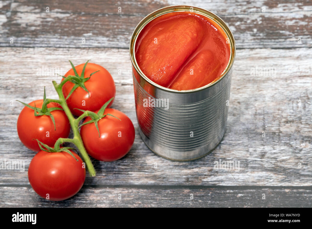 An open can of tomatoes and fresh tomatoes Stock Photo - Alamy