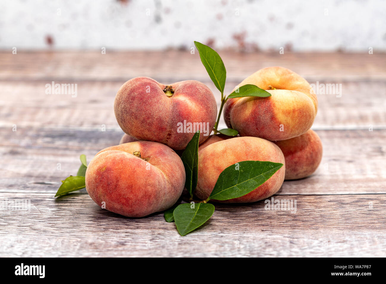Flat peaches with leaves Stock Photo - Alamy
