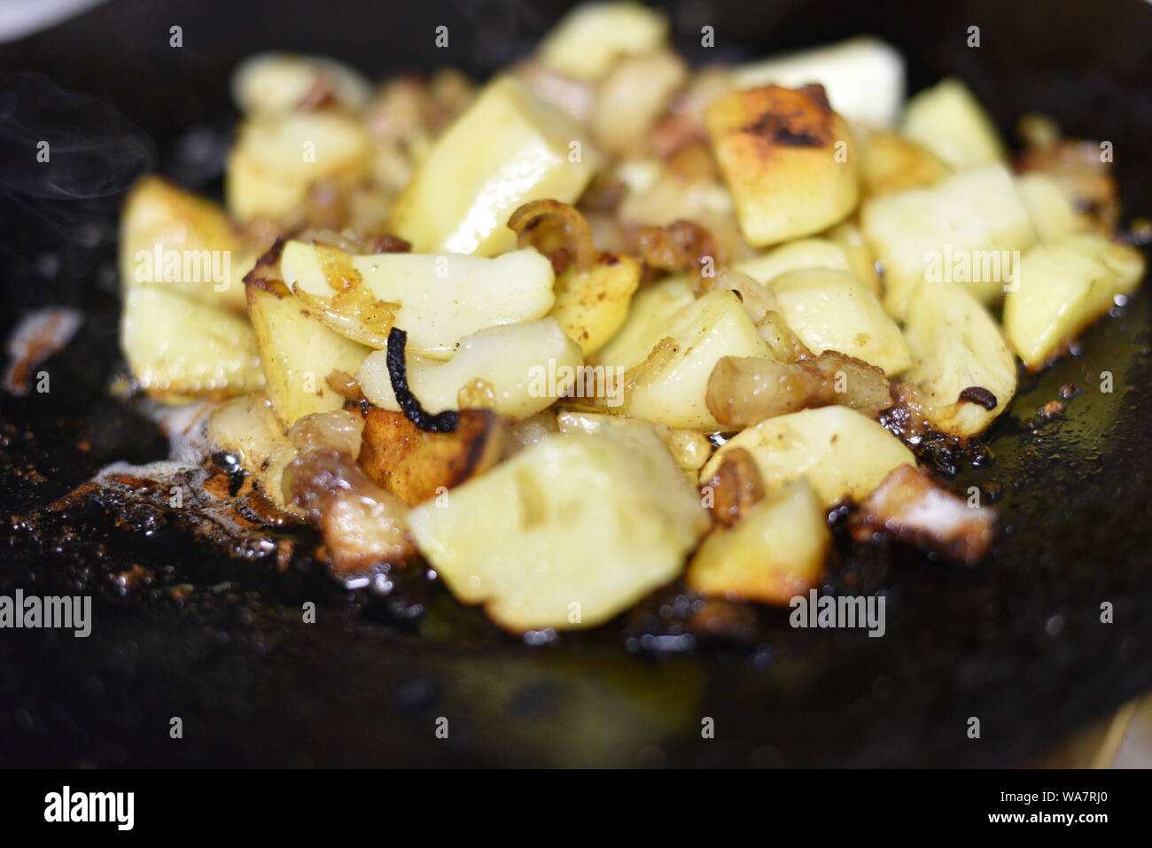 Cooking fried potatoes in outdoor conditions on fire. Fire fried ...