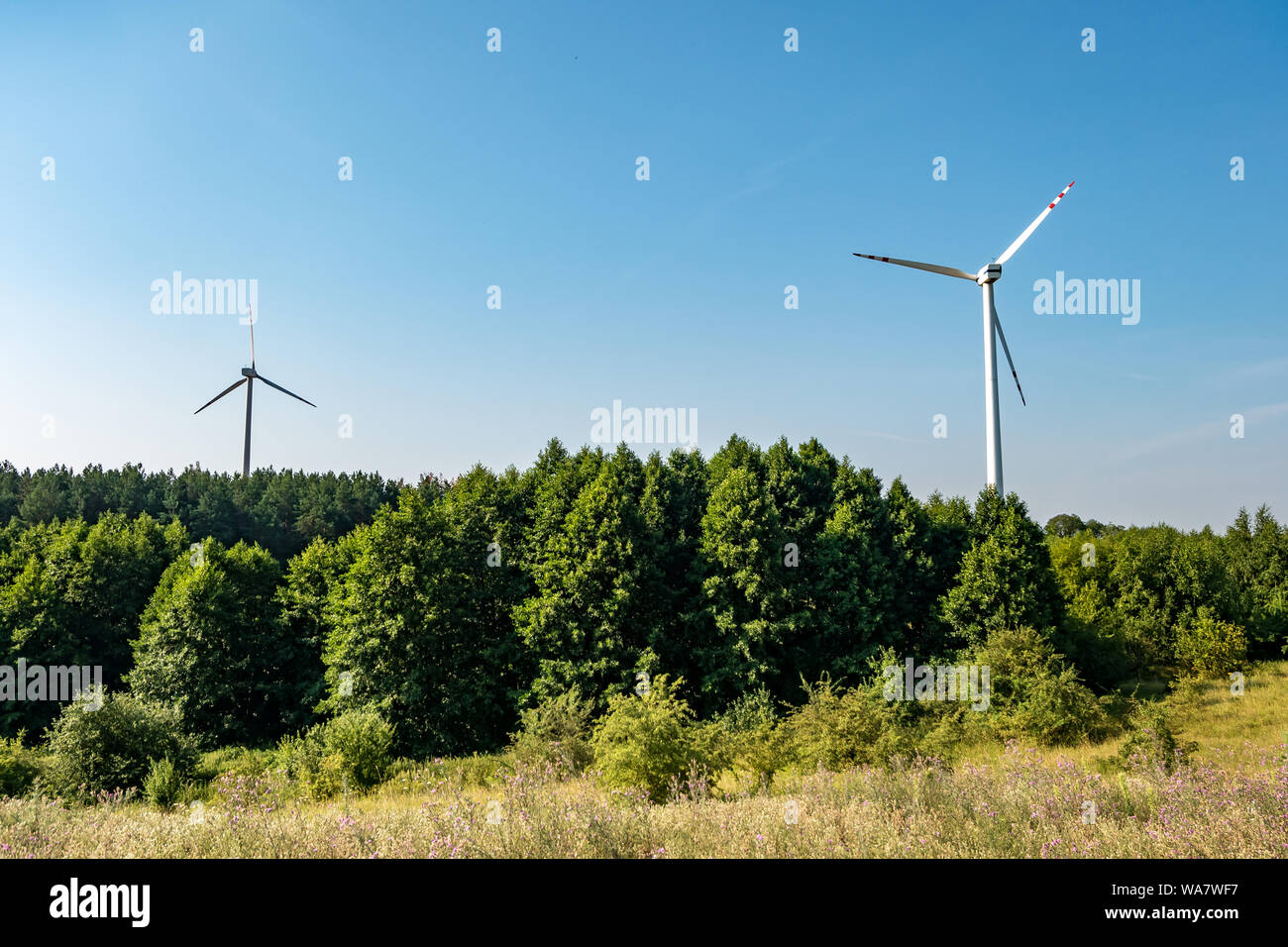 rotating blades of a windmill propeller on blue sky background. Wind ...