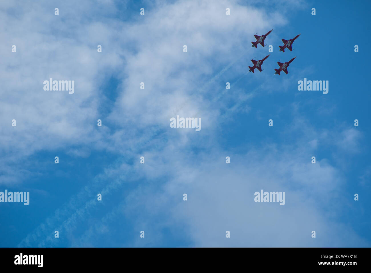 4 planes in formation of Patrouille Suisse at blue sky with clouds at ...