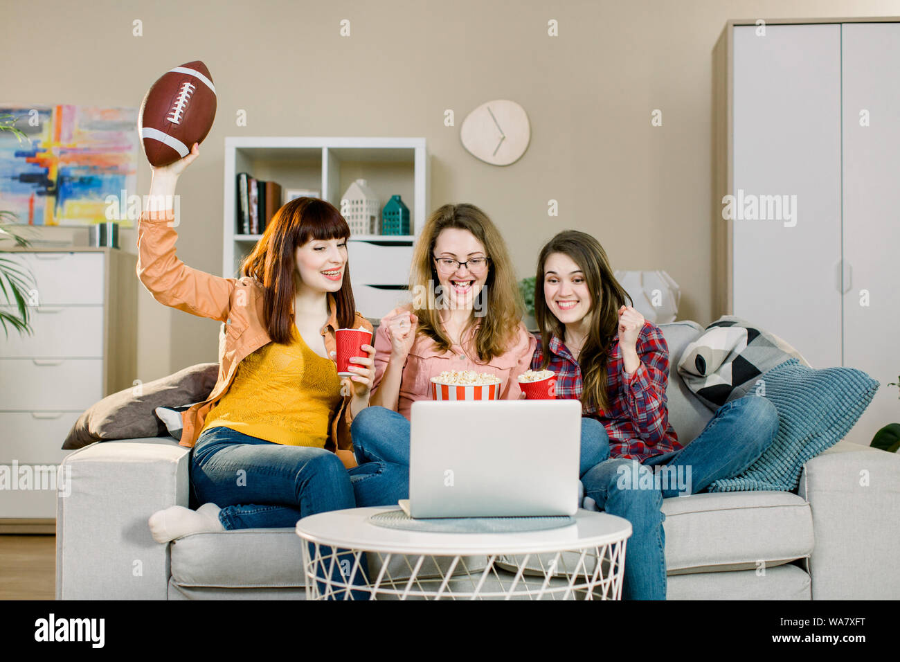 Female friends cheering sport league, watching football together at ...
