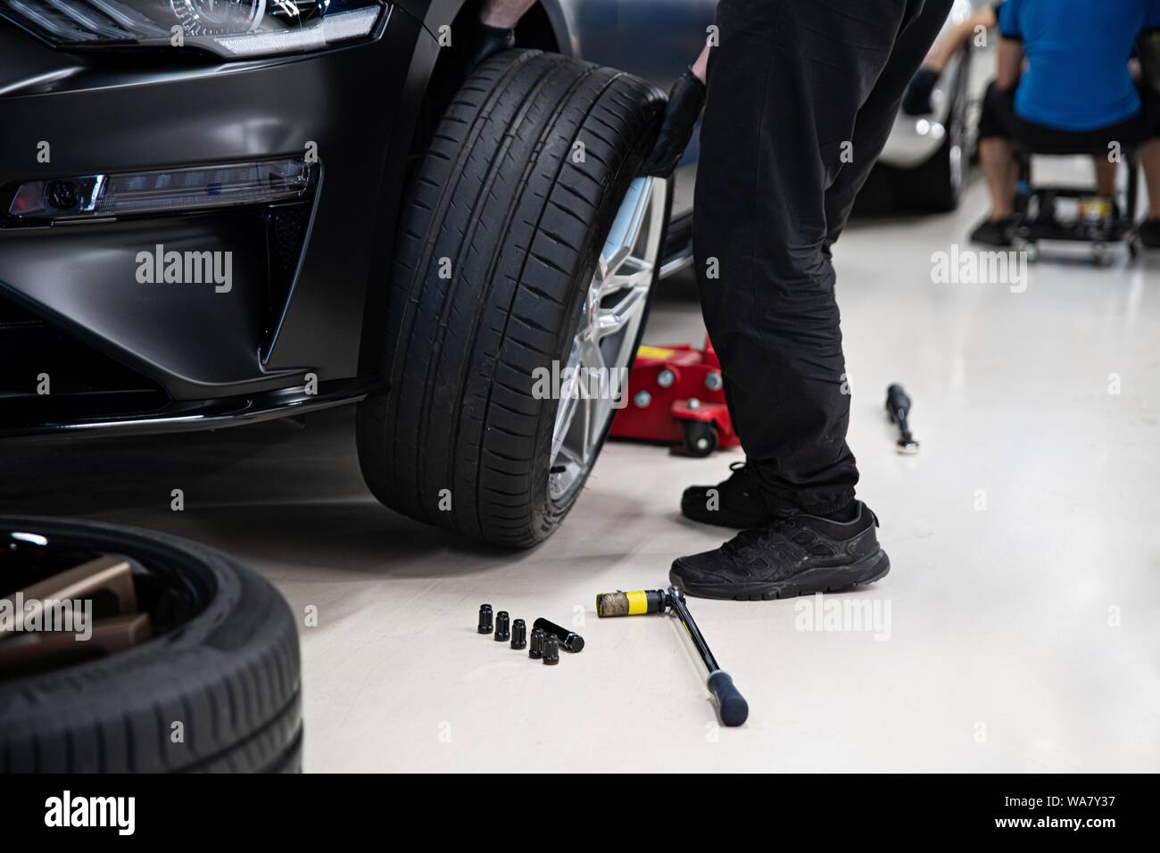 Mechanic changing wheel and tire in car service Stock Photo - Alamy