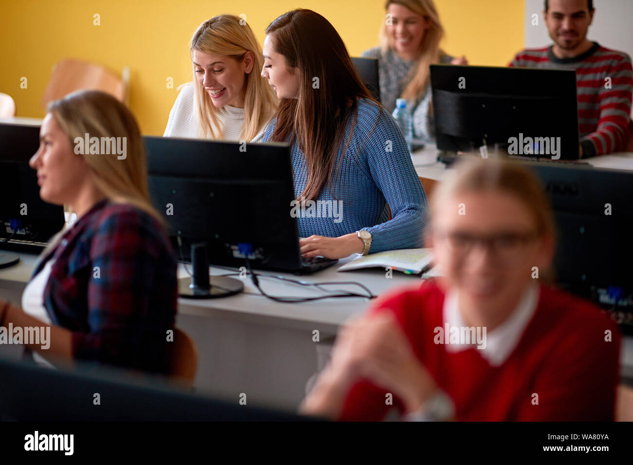young students having fun and smiling in lecture hall of modern college ...