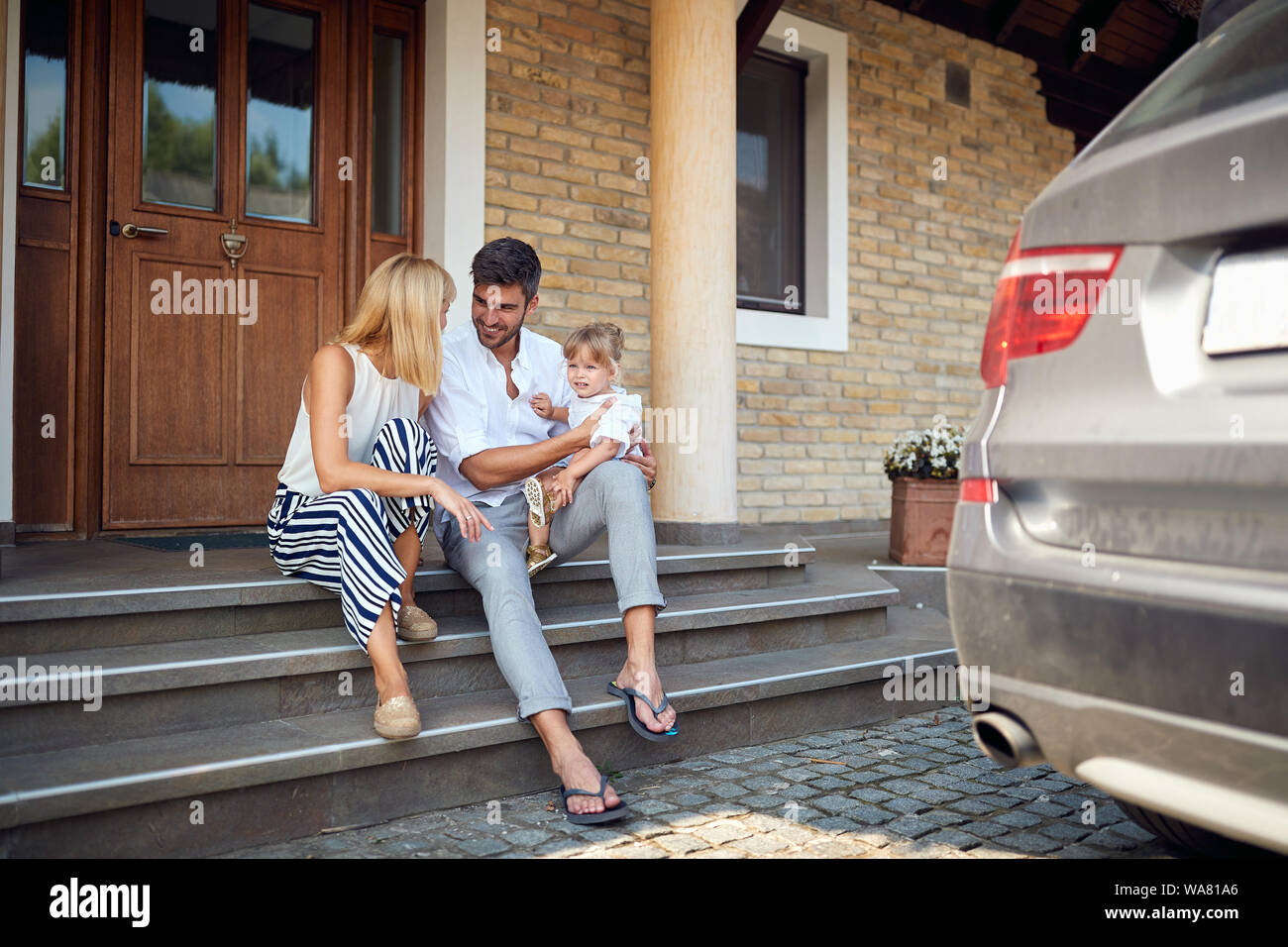 Happy parents with little daughter enjoining outside Stock Photo - Alamy