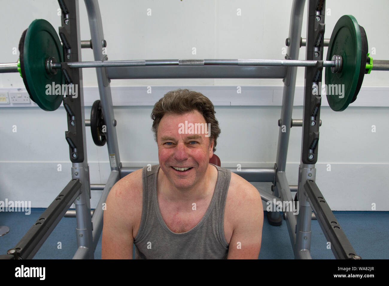An head and shoulders portrait of a man smiling for the camera as he ...