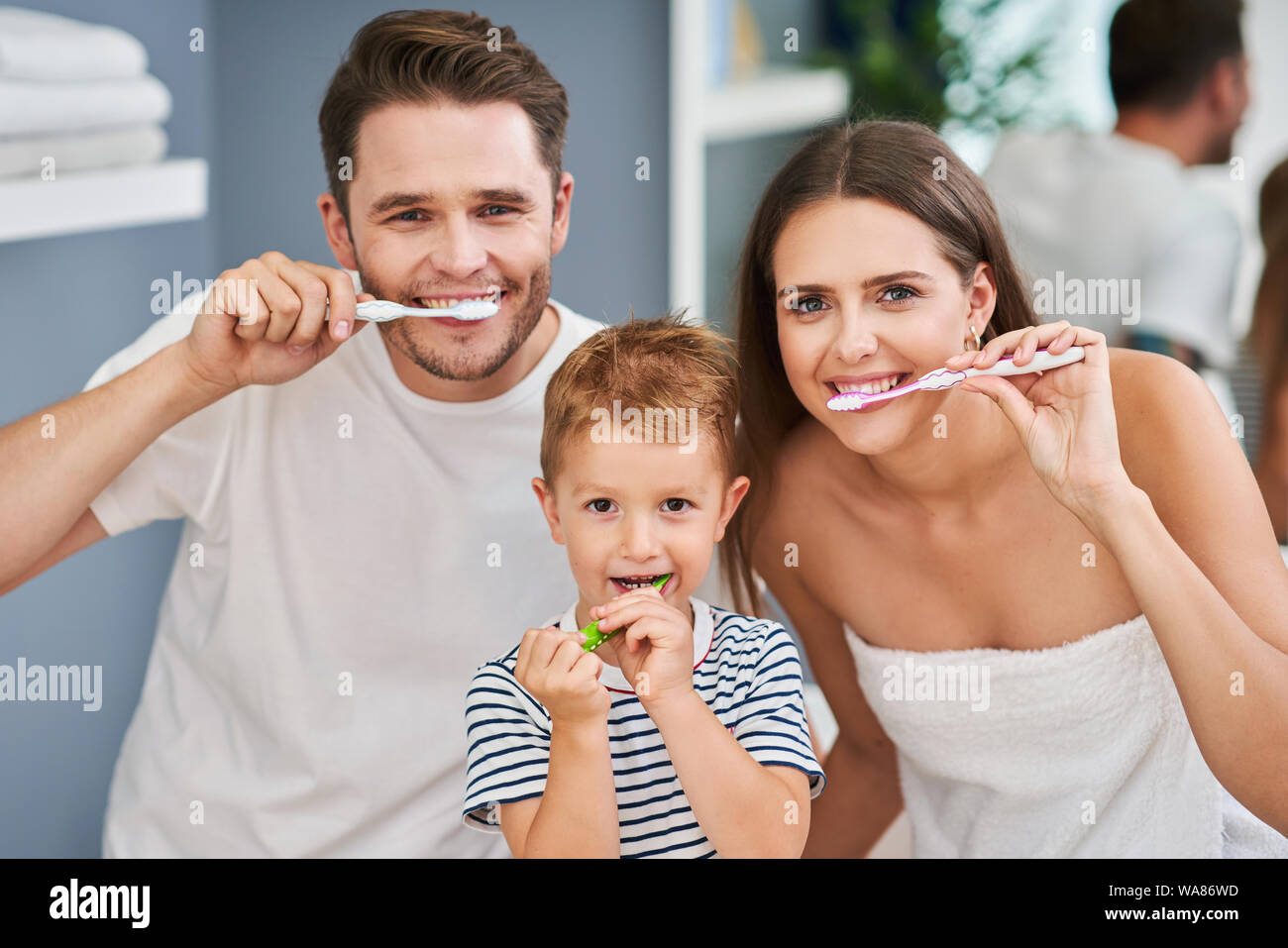 Portrait of happy family brushing teeth in the bathroom Stock Photo - Alamy