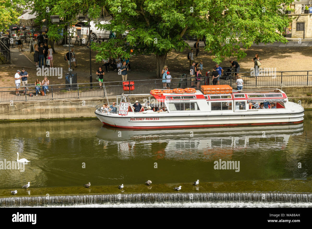 BATH, ENGLAND - JULY 2019: Tourist river cruise boat at Pulteney Weir ...