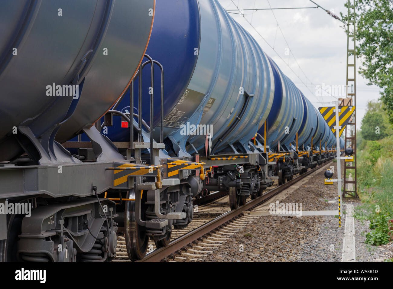 Side view of freight train with petroleum tank cars on railroad track ...