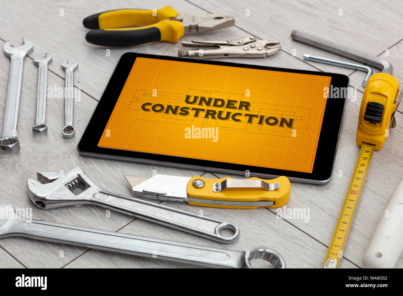 Tablet and tools with home under construction concept Stock Photo - Alamy