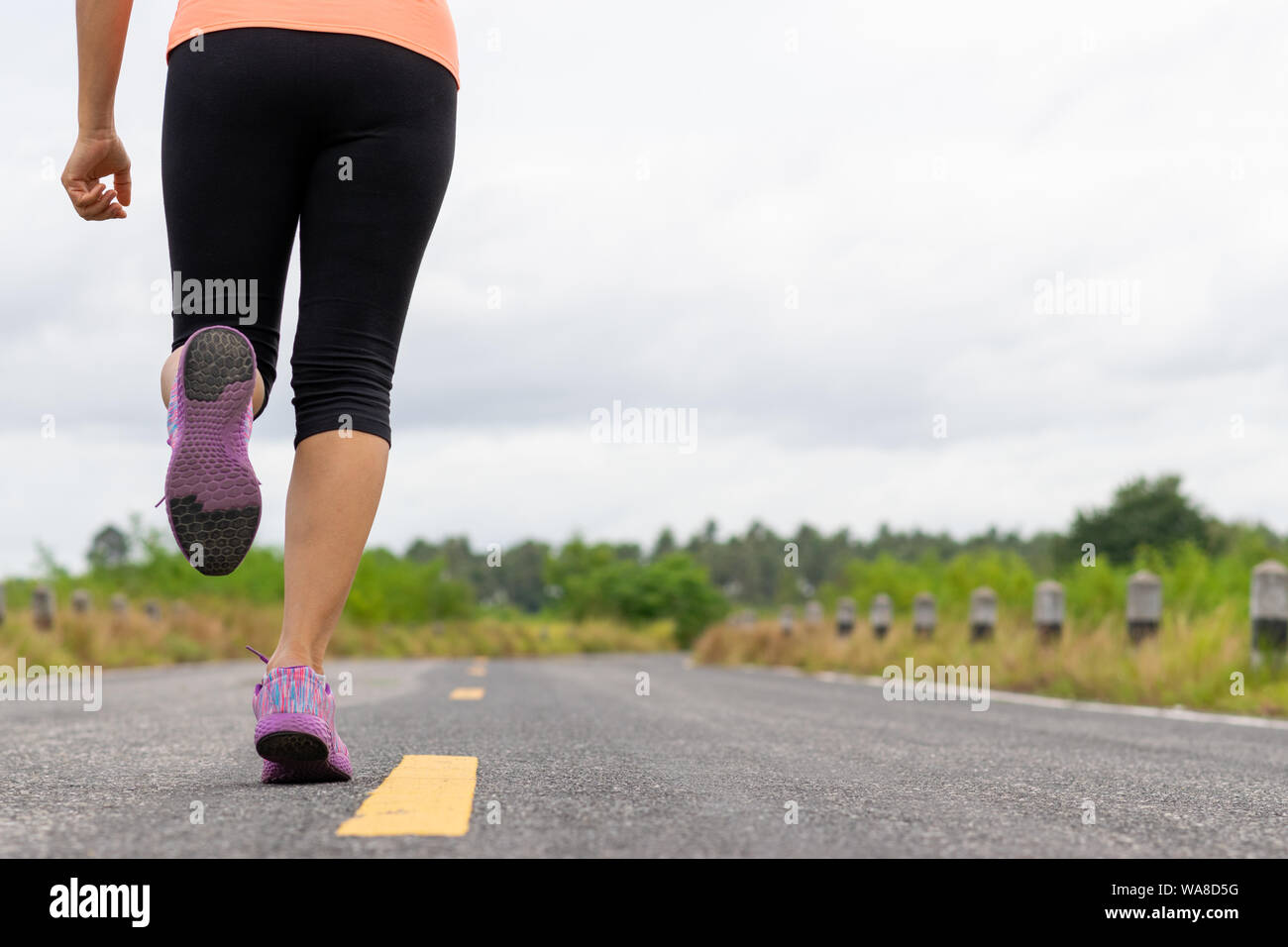 Closeup woman running towards on the road side. Step, run and outdoor ...