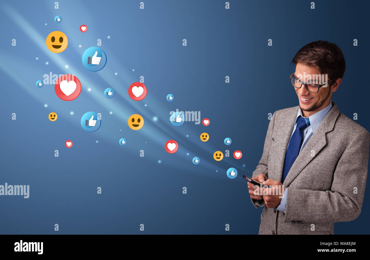Young person using smartphone with flying social media icons around ...
