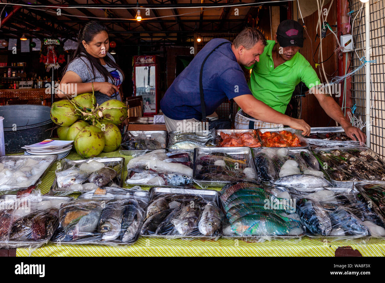 A Tourist Chooses Shellfish From A Restaurant Seafood Display, El Nido ...