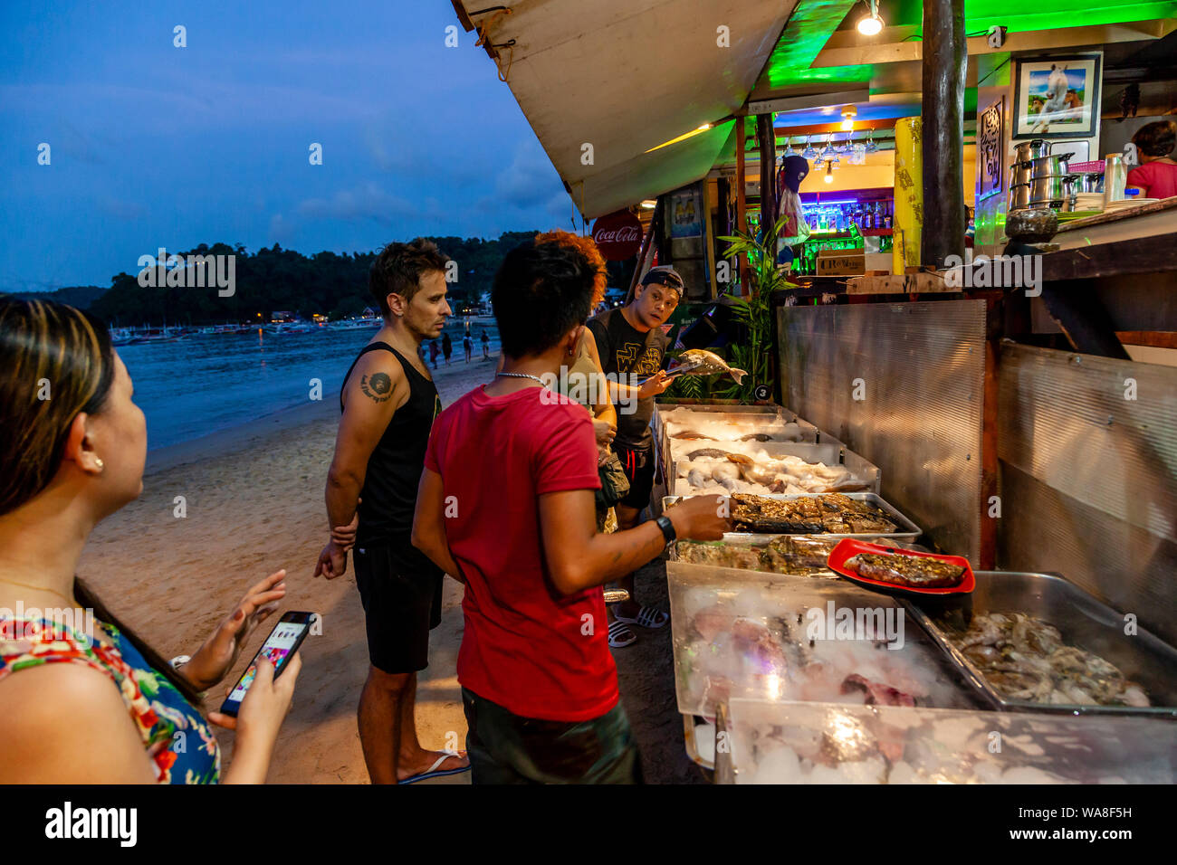 Tourists Choosing Fish From The Fresh Seafood Display Outside A ...