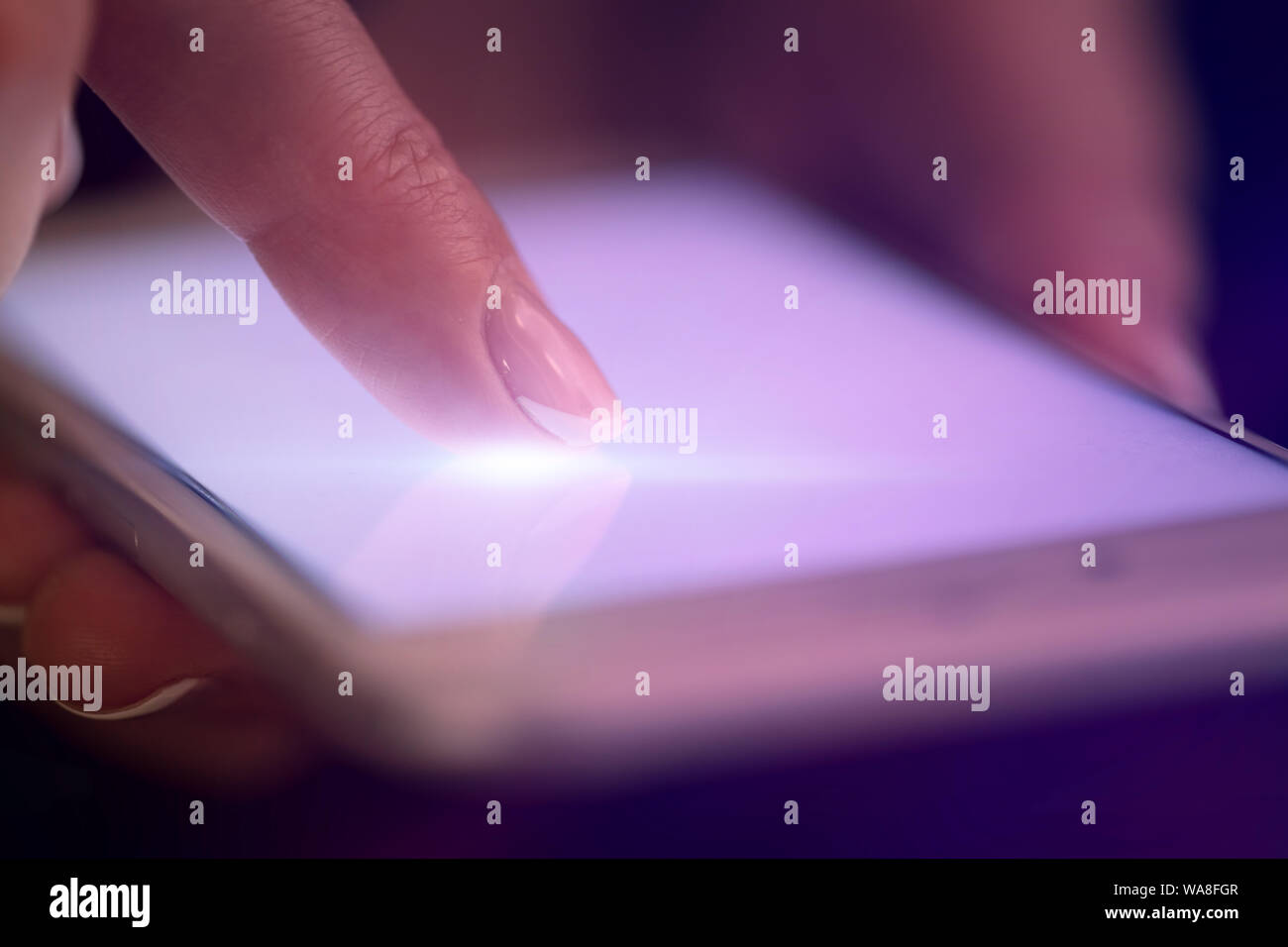 Finger touching phone with dark background with copyspace Stock Photo ...