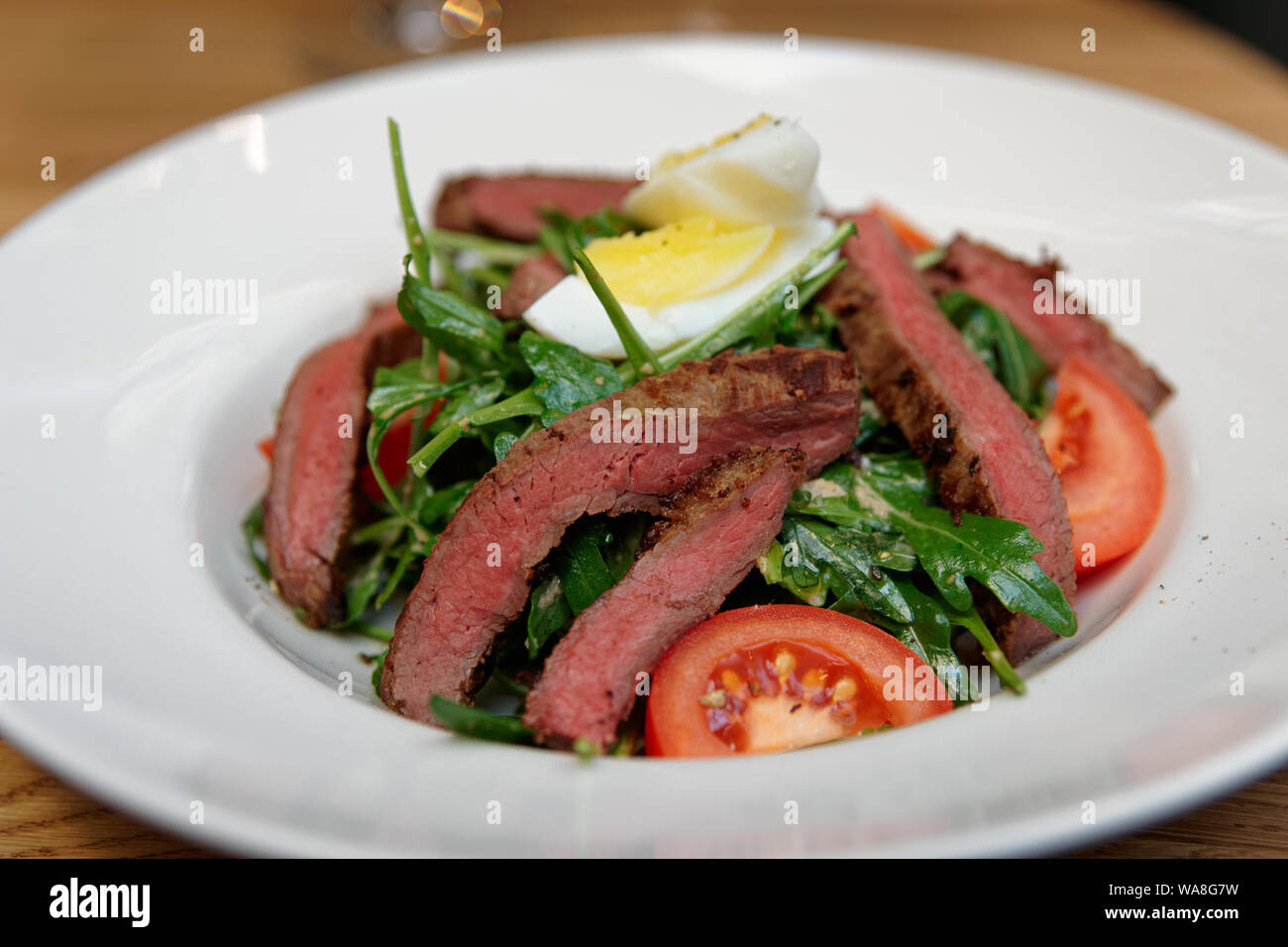 Roast beef starter with arugula salad and eggs on white plate Stock ...