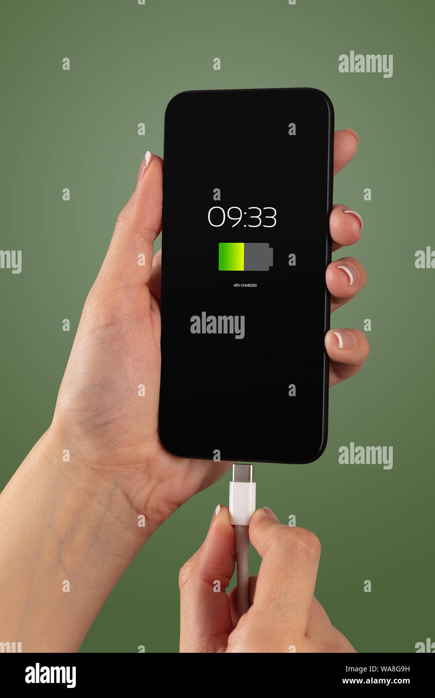 Elegant hand charging smartphone with low battery Stock Photo - Alamy