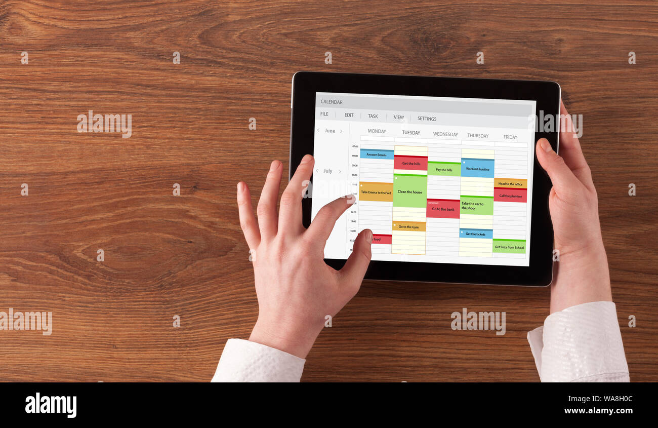 Hand holding tablet with timetable and calendar concept Stock Photo - Alamy