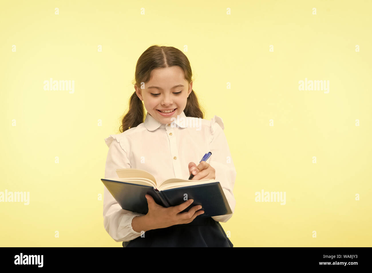 Making notes. Child school uniform kid doing homework. Child girl ...