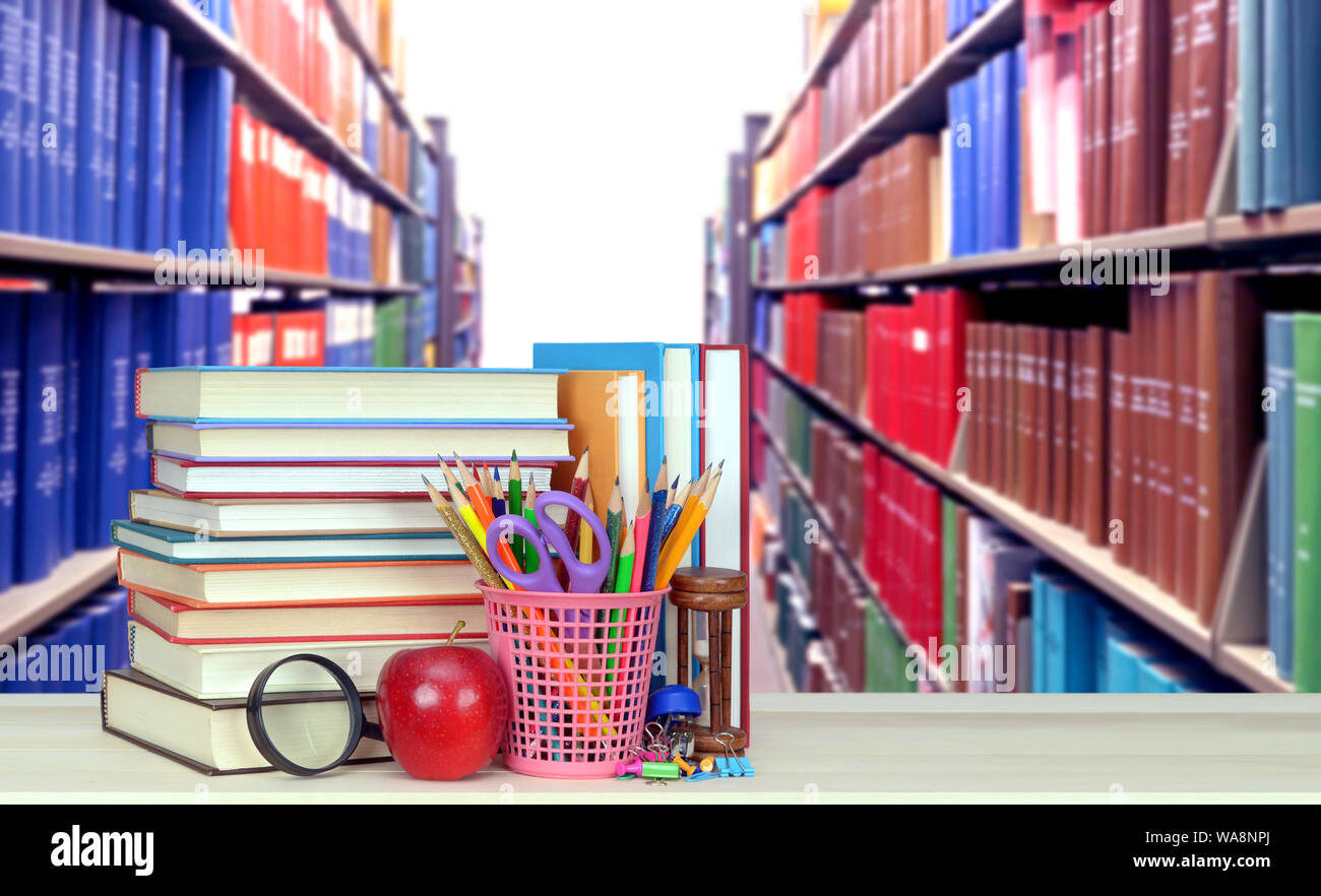 Education concept with stack of book in the very blurry library ...