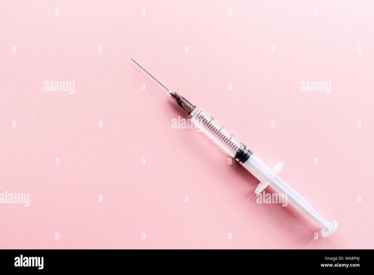 Medical syringe on pink background, give an injection and be healthy ...