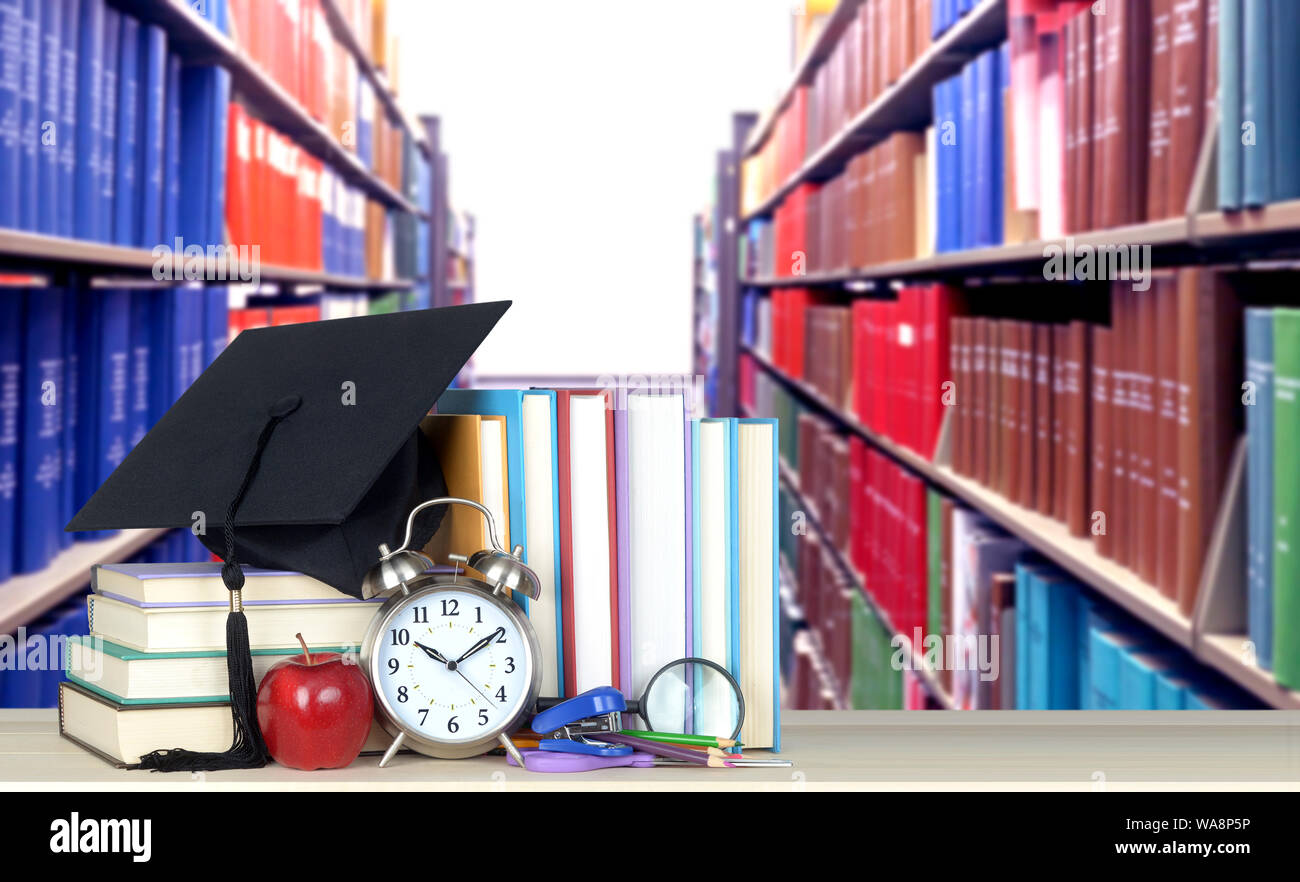 Education concept with stack of book in the very blurry library ...