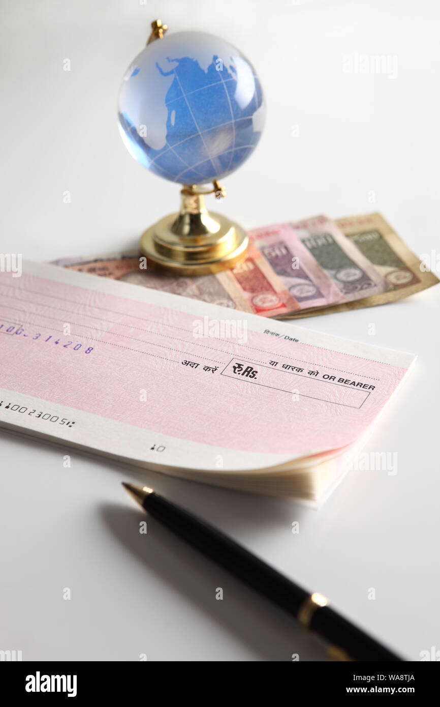 Close up of a globe with cheque book and pen Stock Photo - Alamy