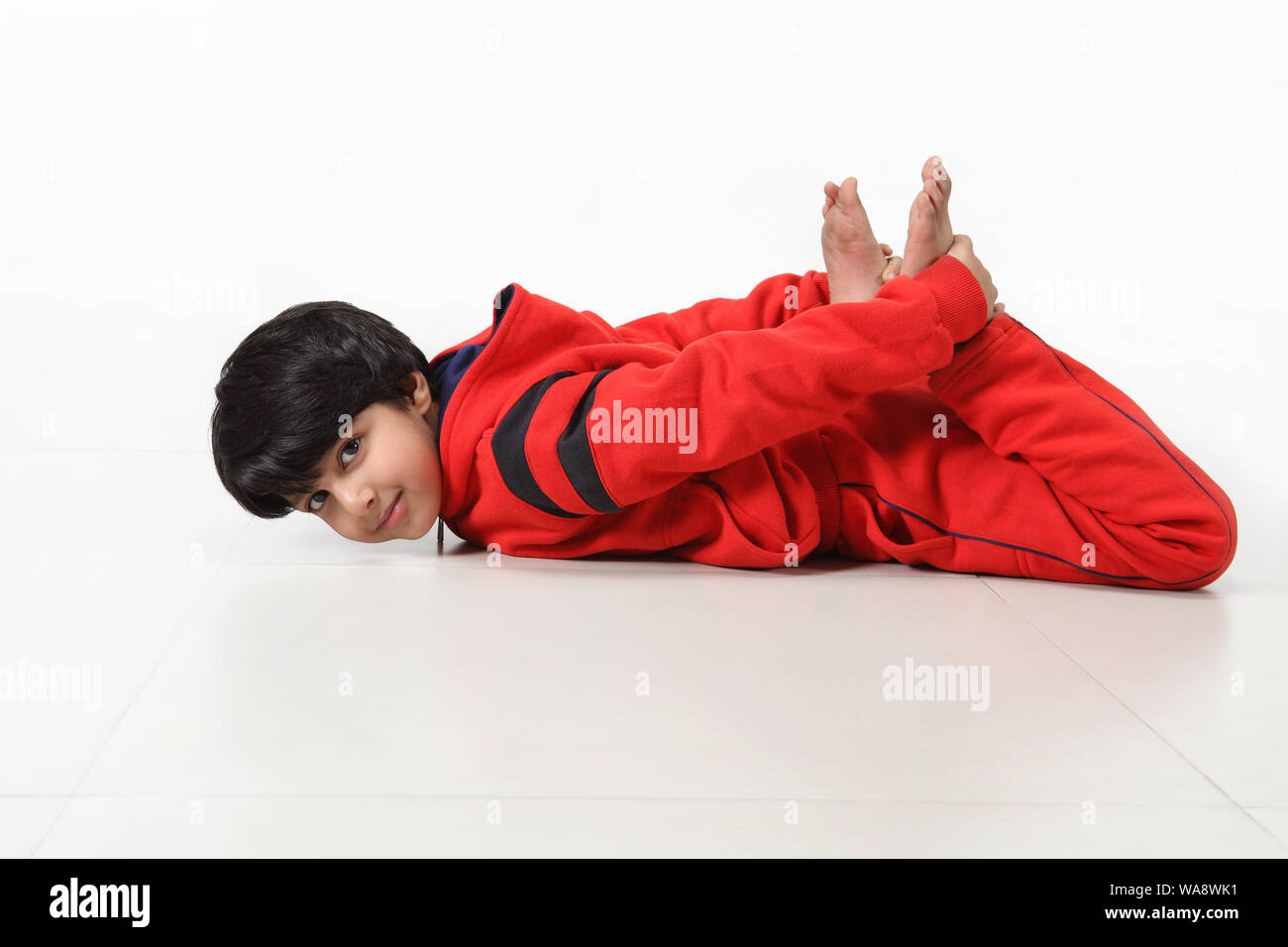 Boy lying down on floor Stock Photo - Alamy