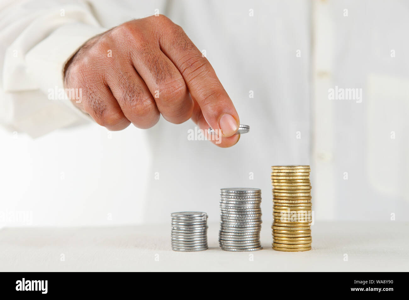 Person hand arranging coins in the shape of bar graph Stock Photo - Alamy