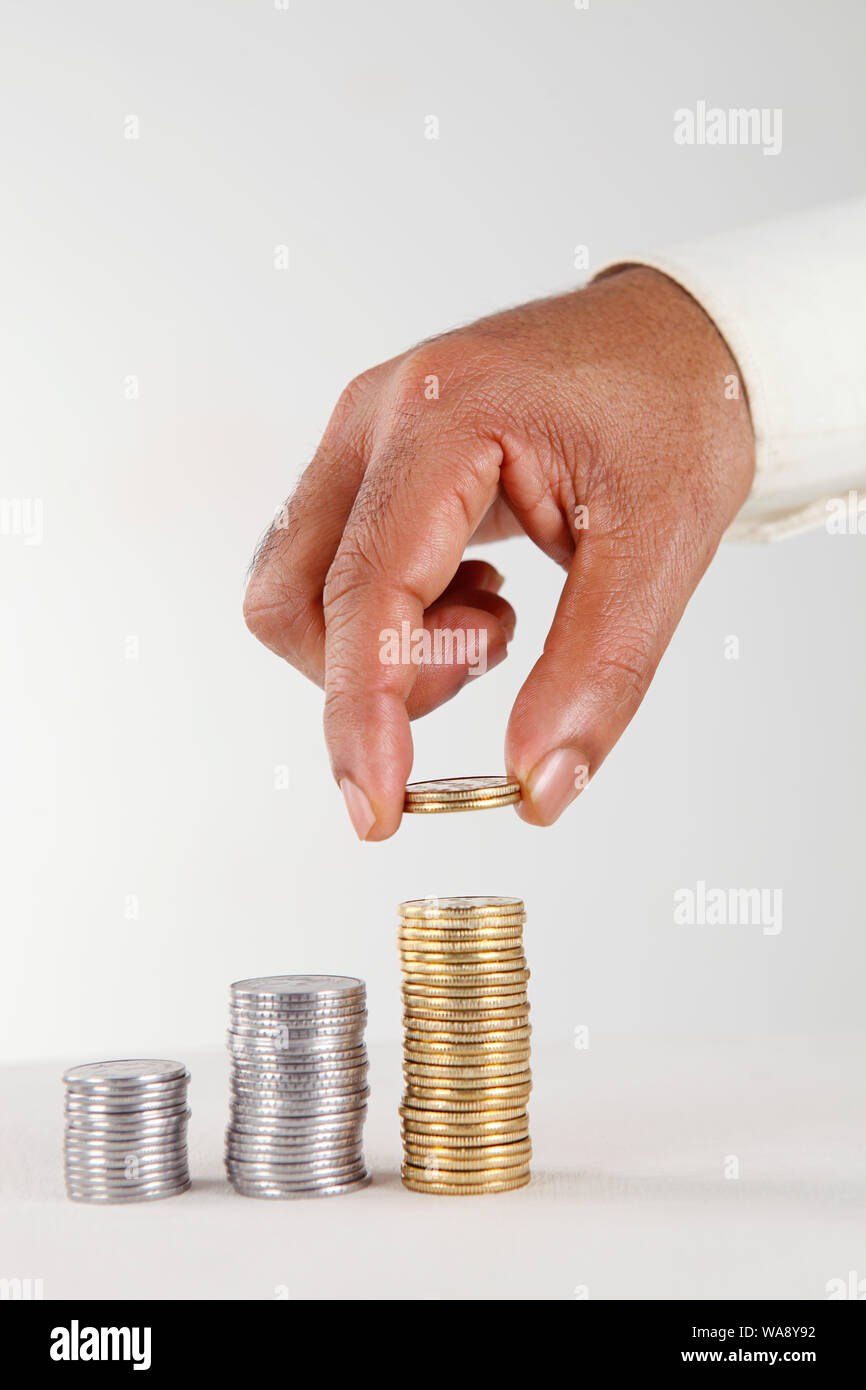 Person hand arranging coins in the shape of bar graph Stock Photo - Alamy