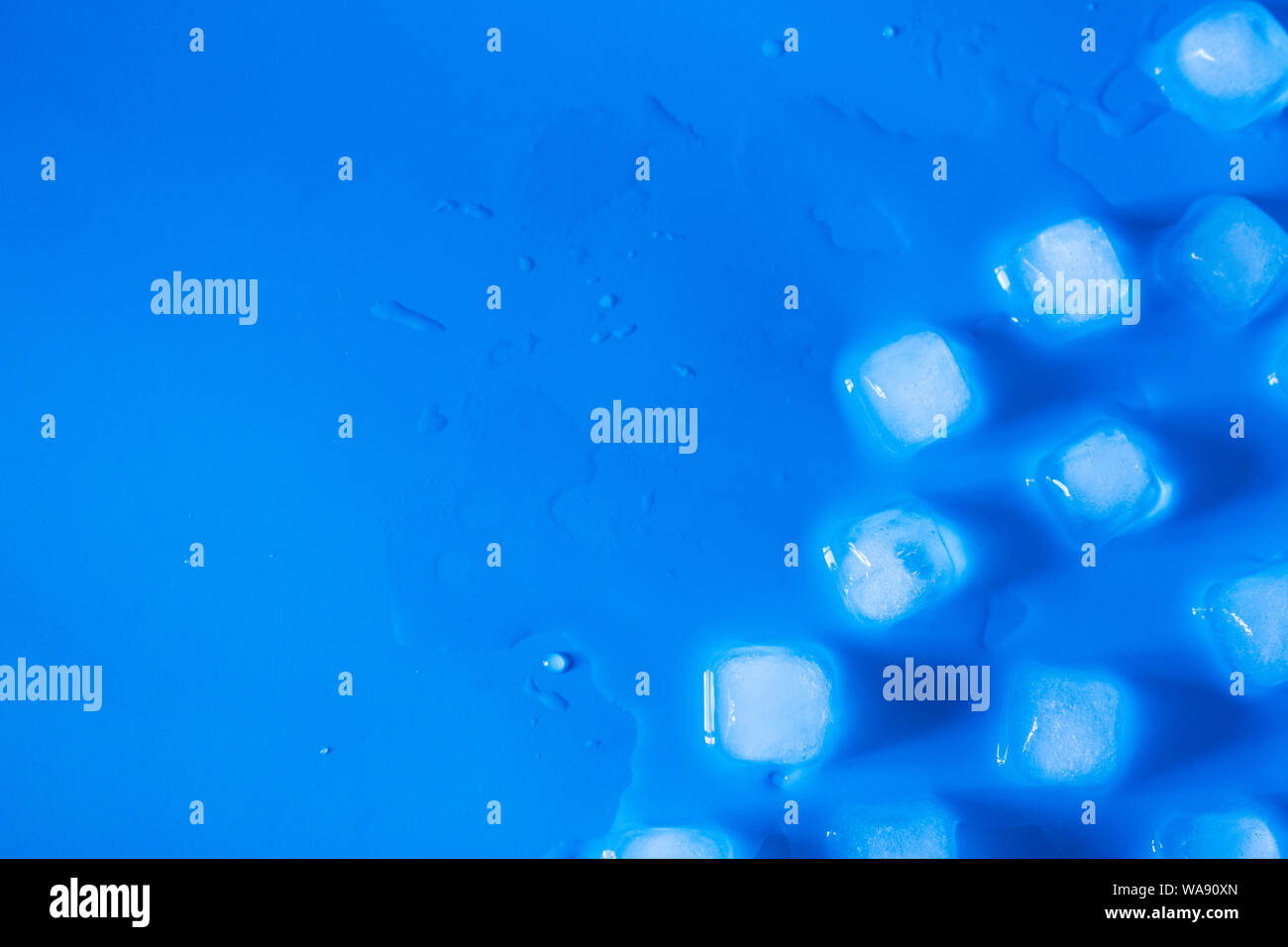 Melting ice cubes background on blue background Stock Photo - Alamy