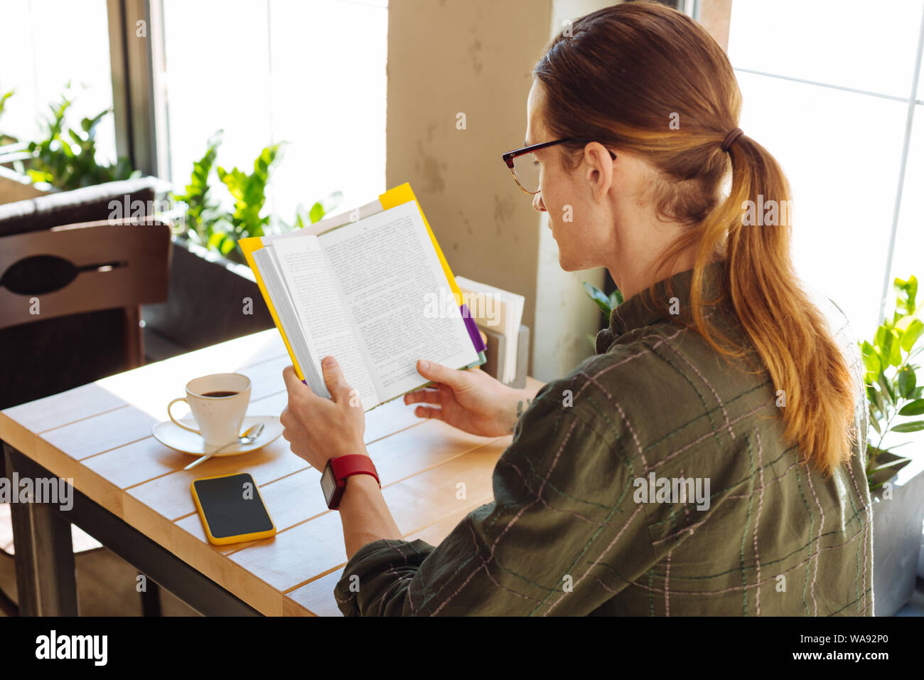 Good looking smart man looking at the book pages Stock Photo - Alamy