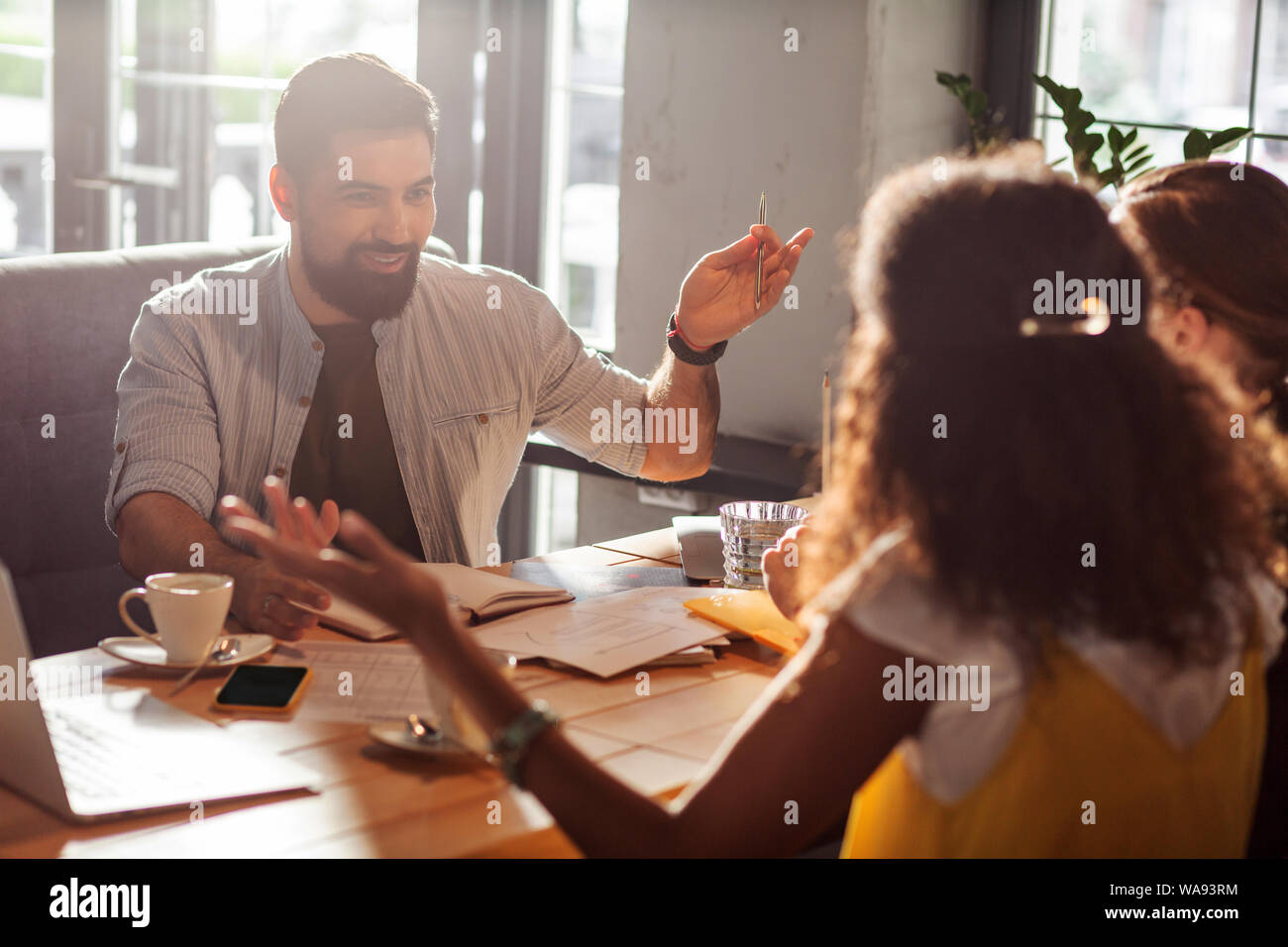 Positive joyful man speaking with his team Stock Photo - Alamy