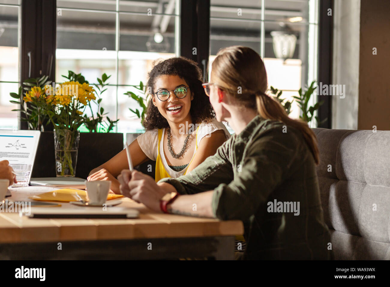 Joyful young woman talking with her friend Stock Photo - Alamy