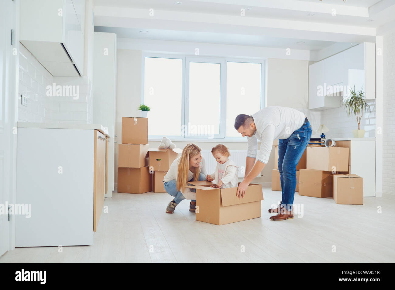 Happy family unpacking boxes at new home Stock Photo - Alamy