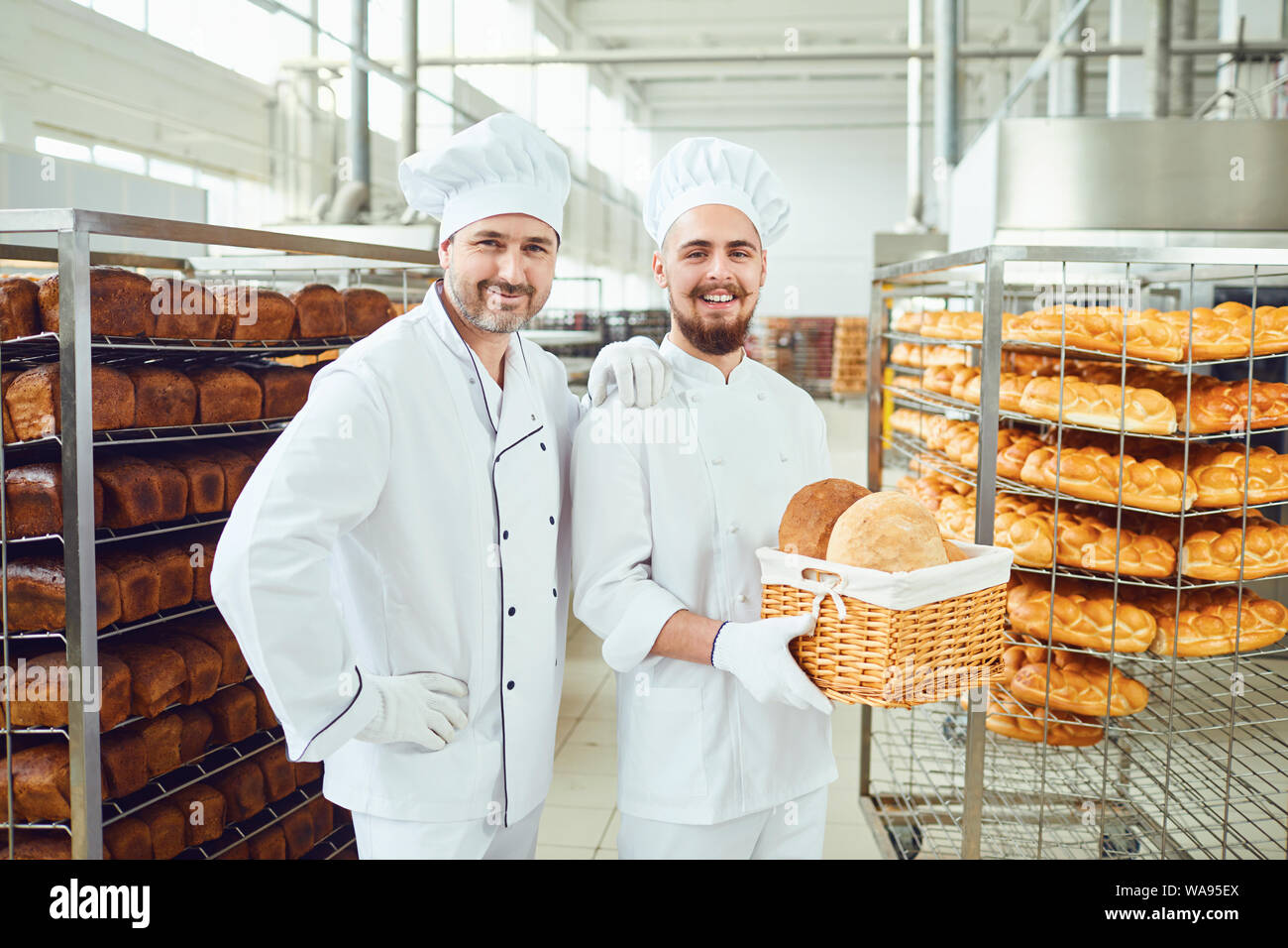 Bakers on the background of trays with breads in a bakery Stock Photo ...