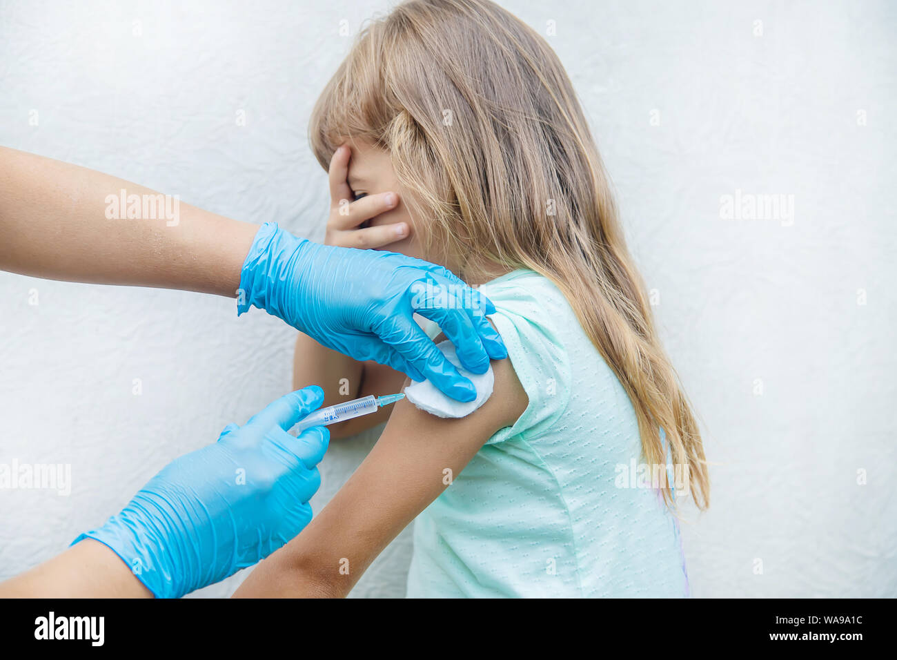 The doctor gives the child an injection in the arm. Selective focus ...