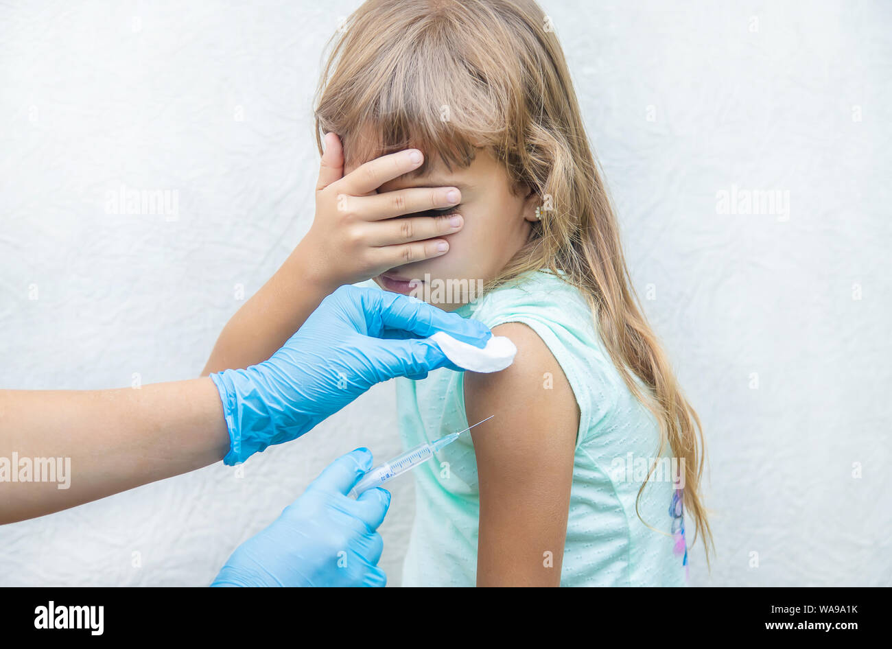 The doctor gives the child an injection in the arm. Selective focus ...