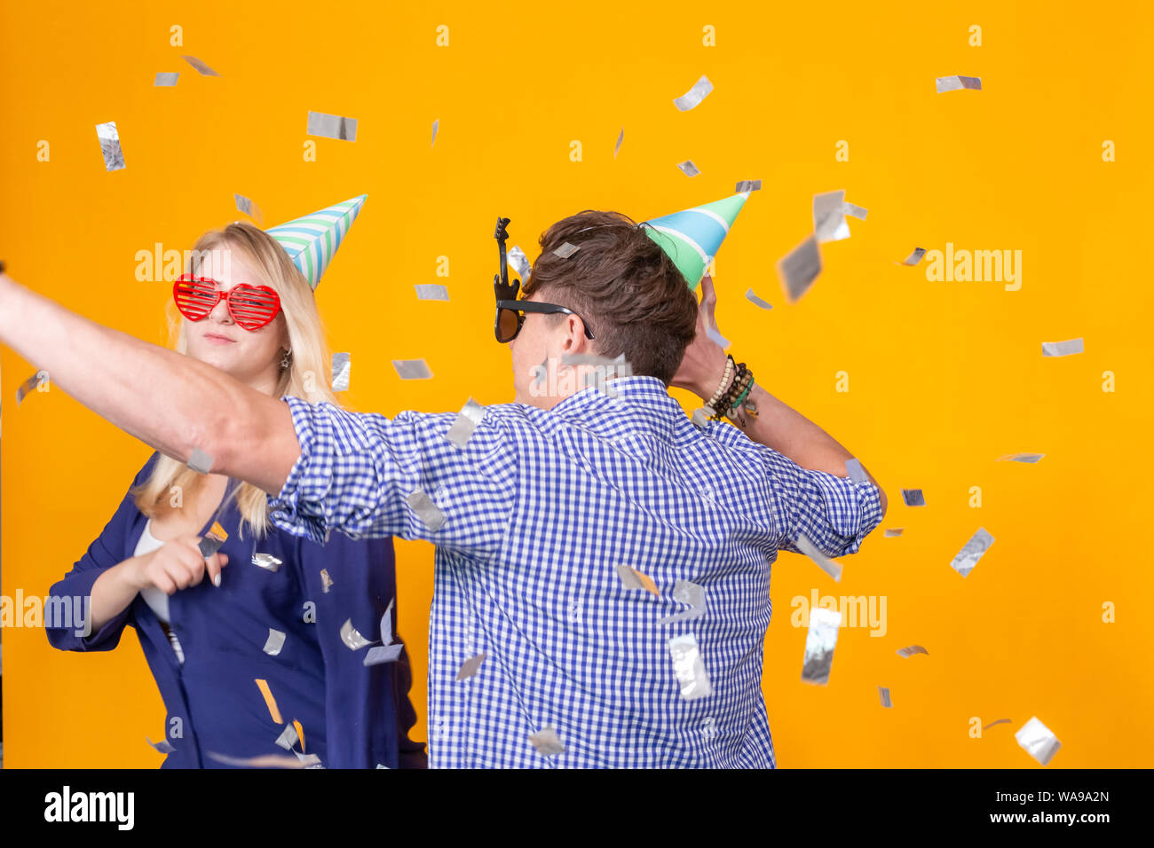 Couple dancing among falling confetti and streamer at party Stock Photo ...