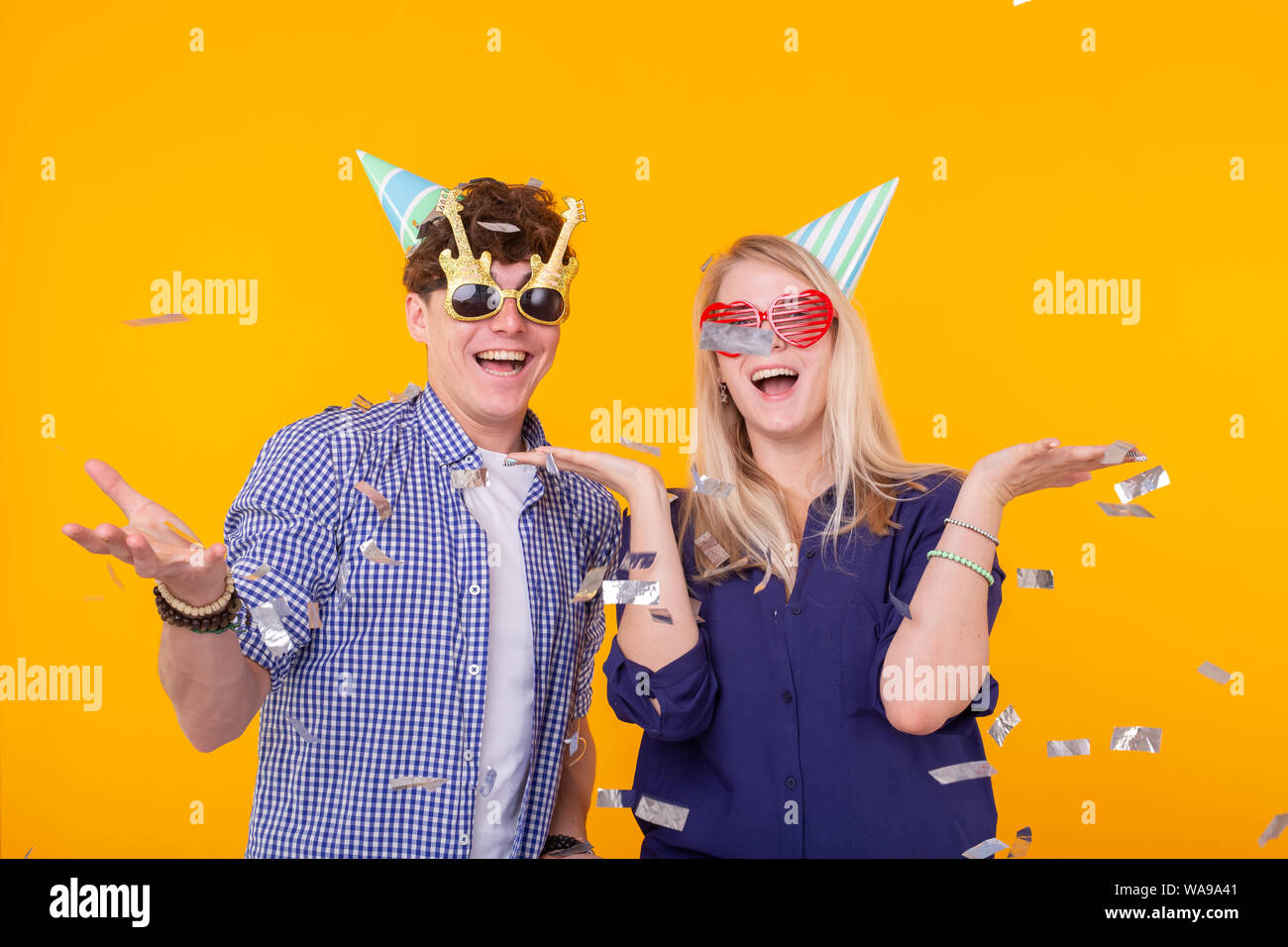 Couple dancing among falling confetti and streamer at party Stock Photo ...