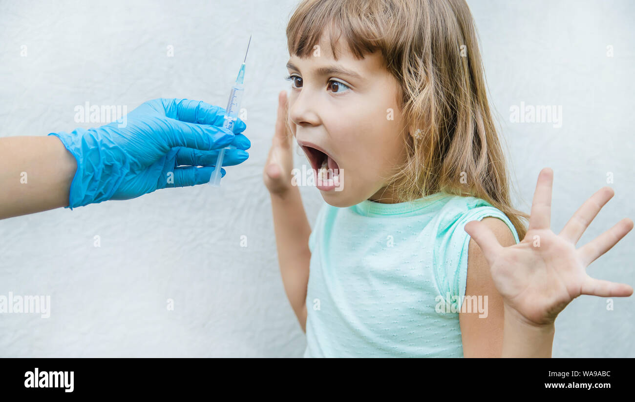 The doctor gives the child an injection in the arm. Selective focus ...