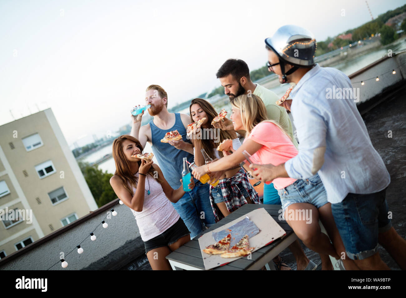 Friends and pizza. Young cheerful people eating pizza and having fun ...